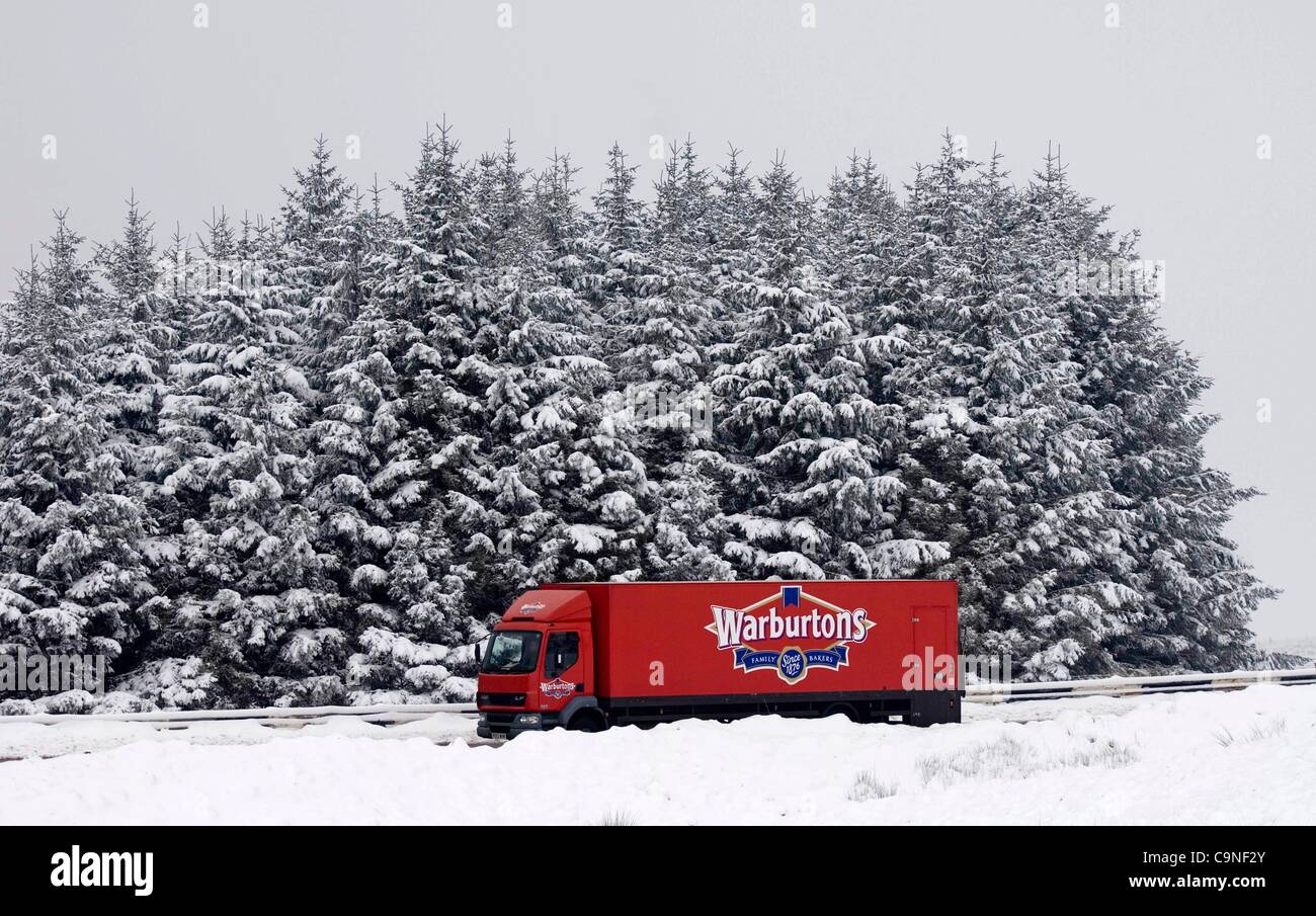 A bread delivery lorry stands out as it makes it's way past snow ...