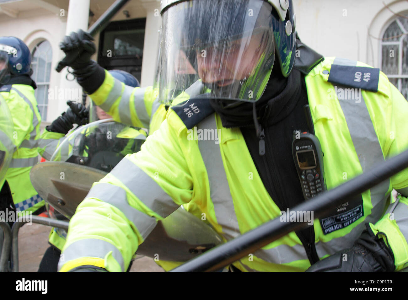 Police officer lunges with baton towards protesters outside the Syrian ...
