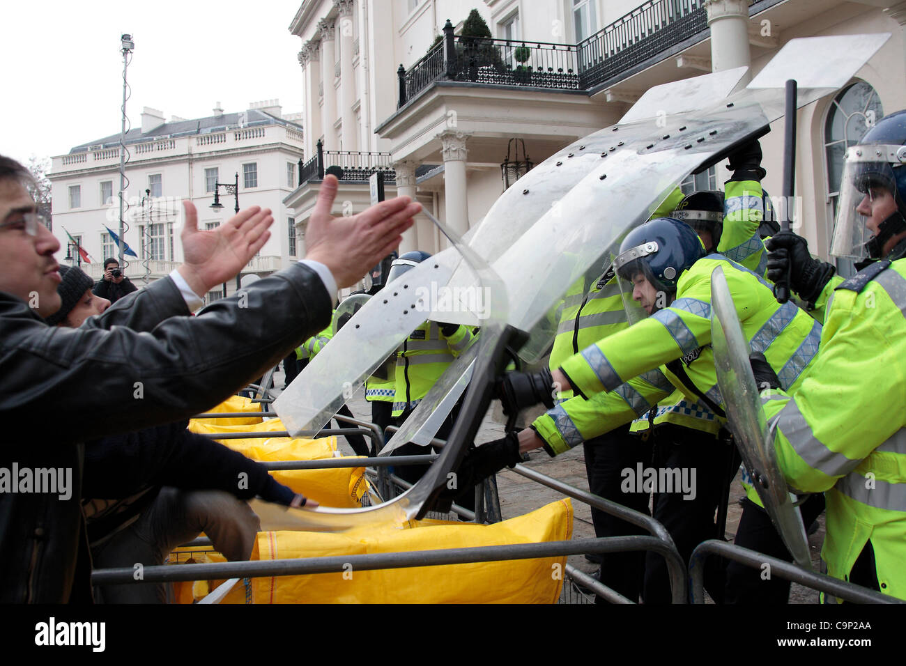 Police use long riot shields to stop protesters storming Syrian Embassy ...