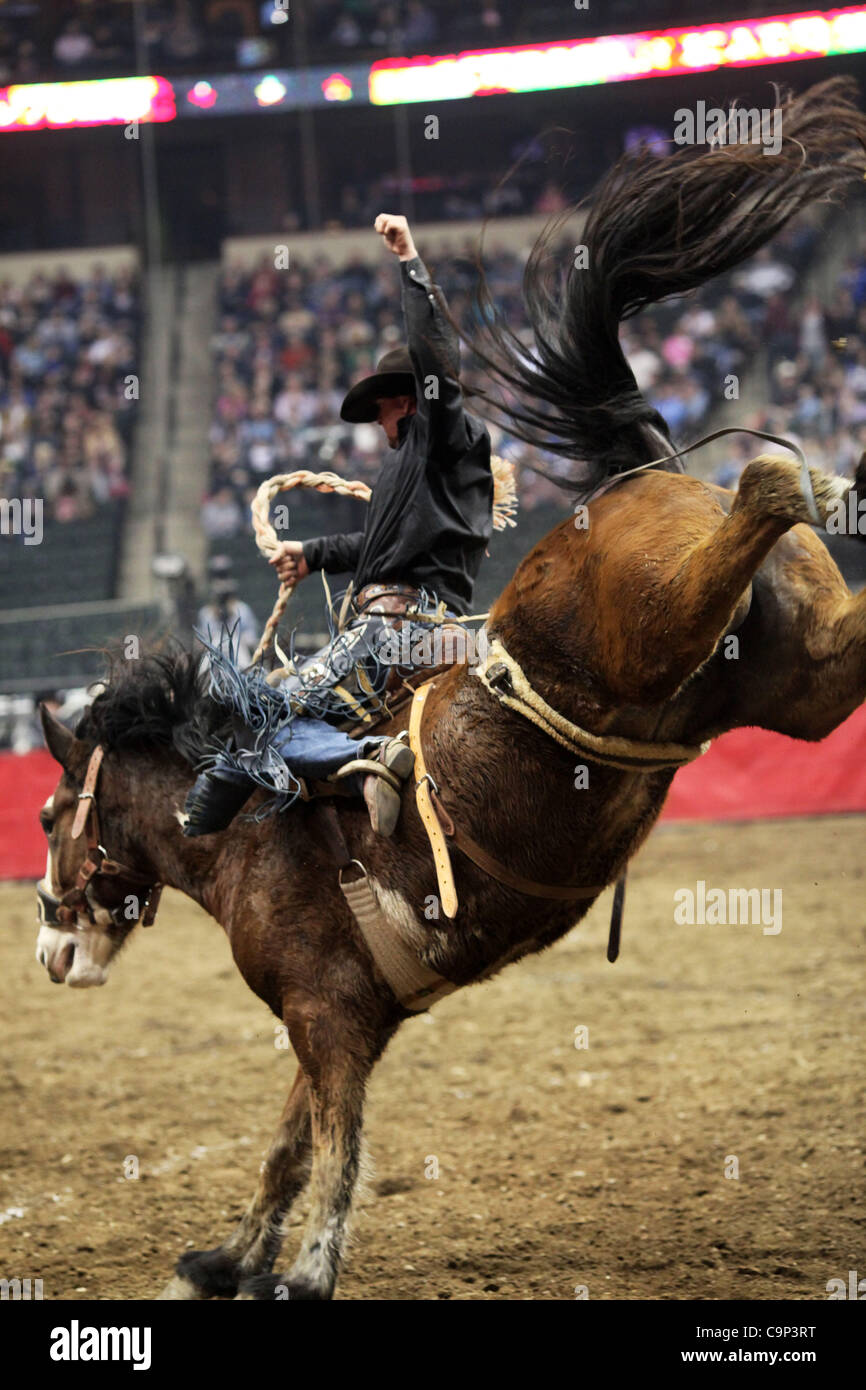 A cowboy rides atop a bucking horse during the "World's Toughest Rodeo ...