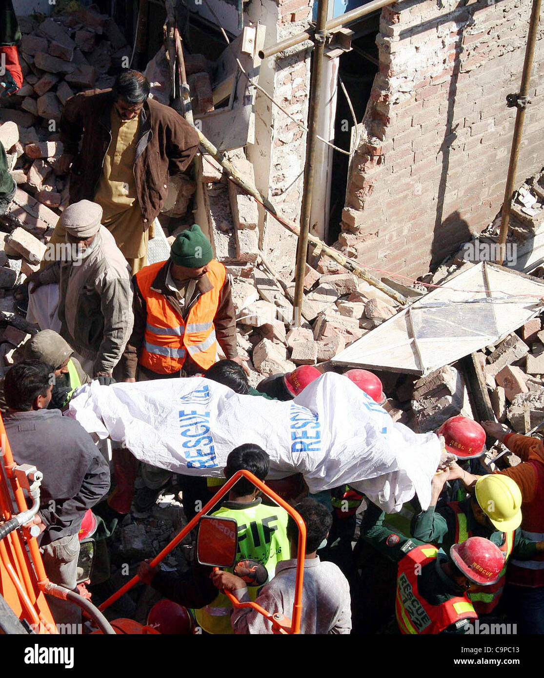 Rescue workers shift dead body of a victim towards ambulance from the ...