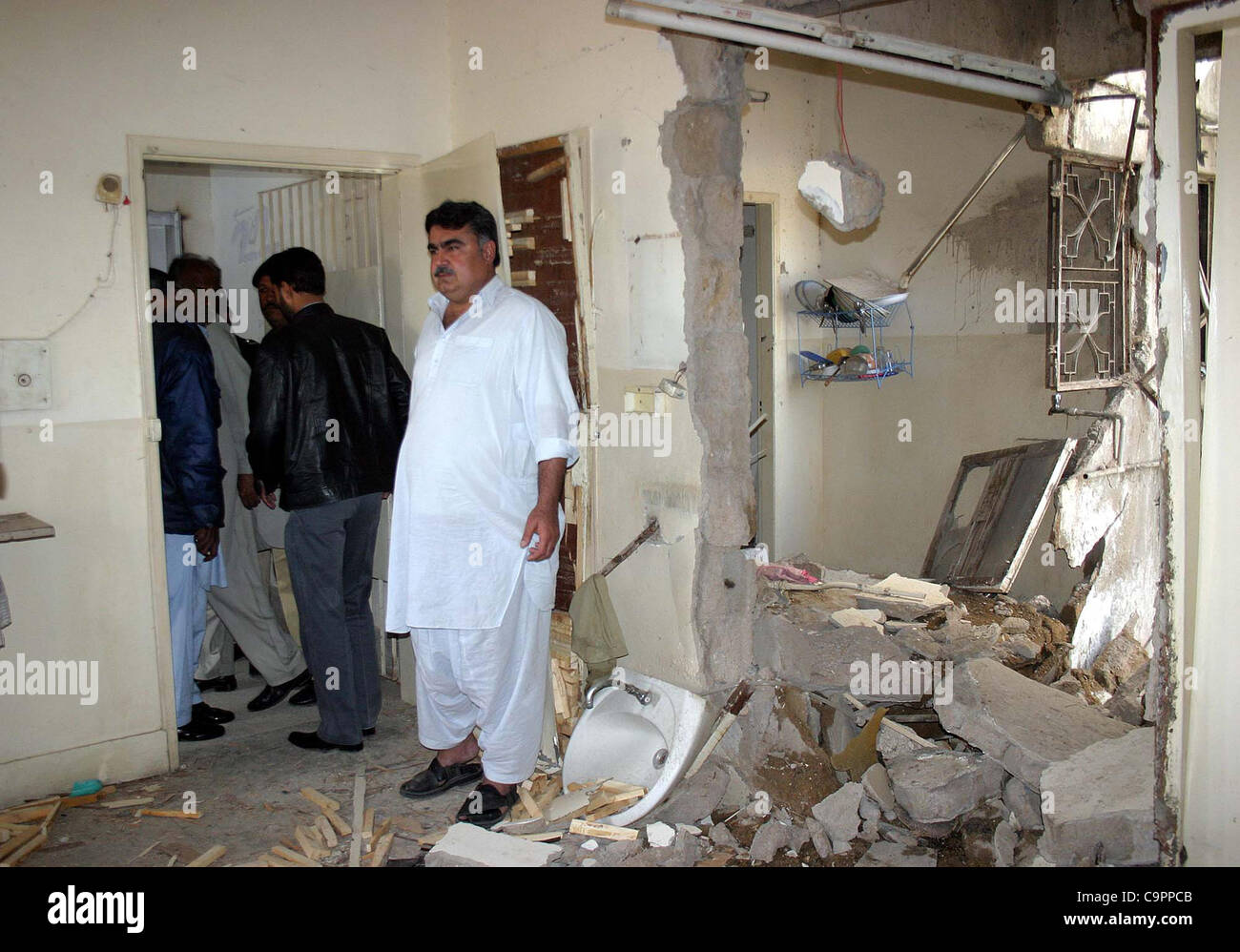 People gather at damaged portion of a flat which was destroyed in ...