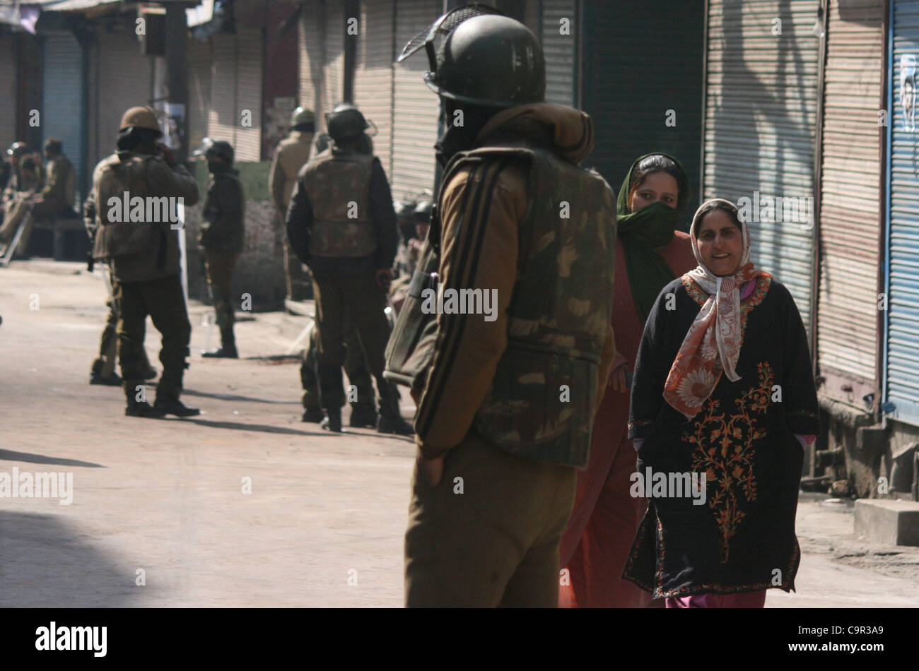 indian police man stand guard as kashmiri muslim women crossing road ...