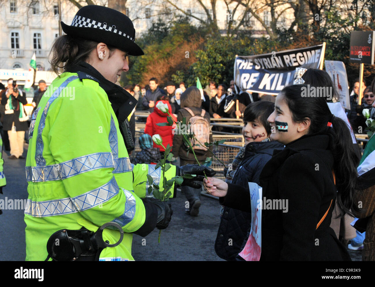 Syrian child gives a rose to a police officer at a protest outside the ...