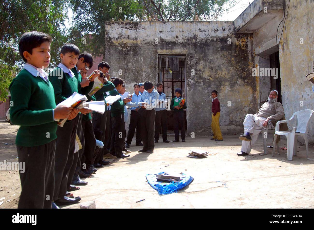 Govt.MC Elementary School for Boys students sit under the open sky ...