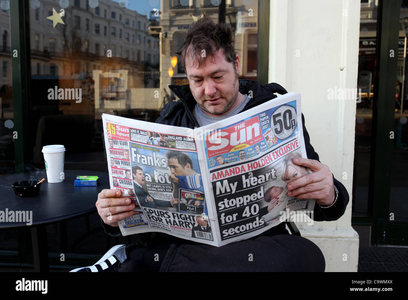 A man pictured reading the new Sun on Sunday newspaper outside a shop ...