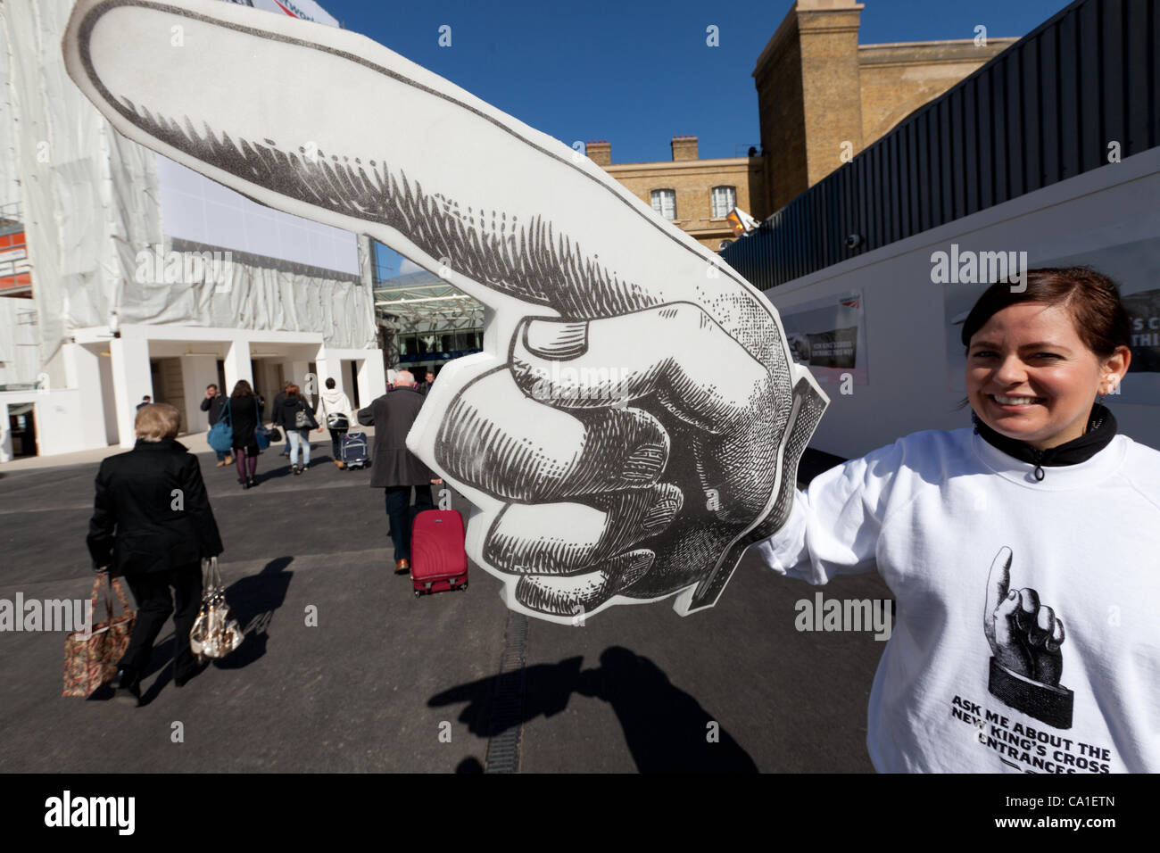 Member of station staff wearing giant comedy hand with large pointing ...