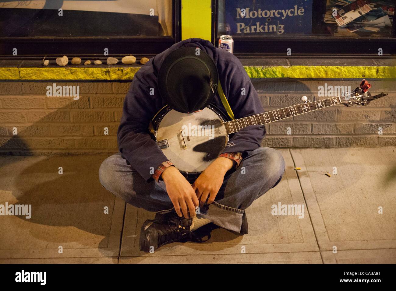 May 30, 2012 - A young banjo player, stricken with grief, rests against ...