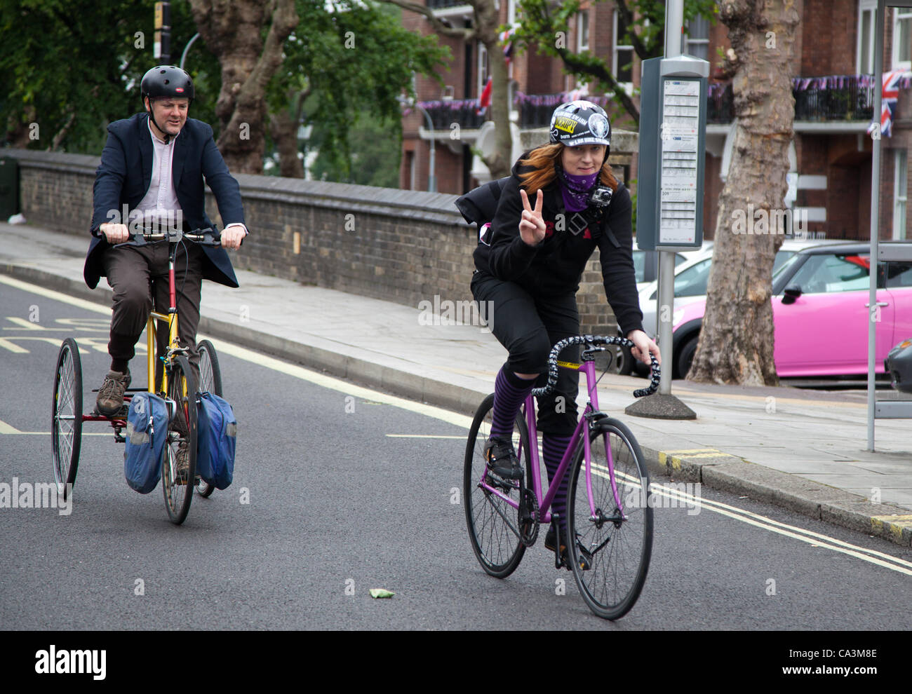 London, UK. 2nd June 2012 A cyclists makes the peace sign as she takes ...
