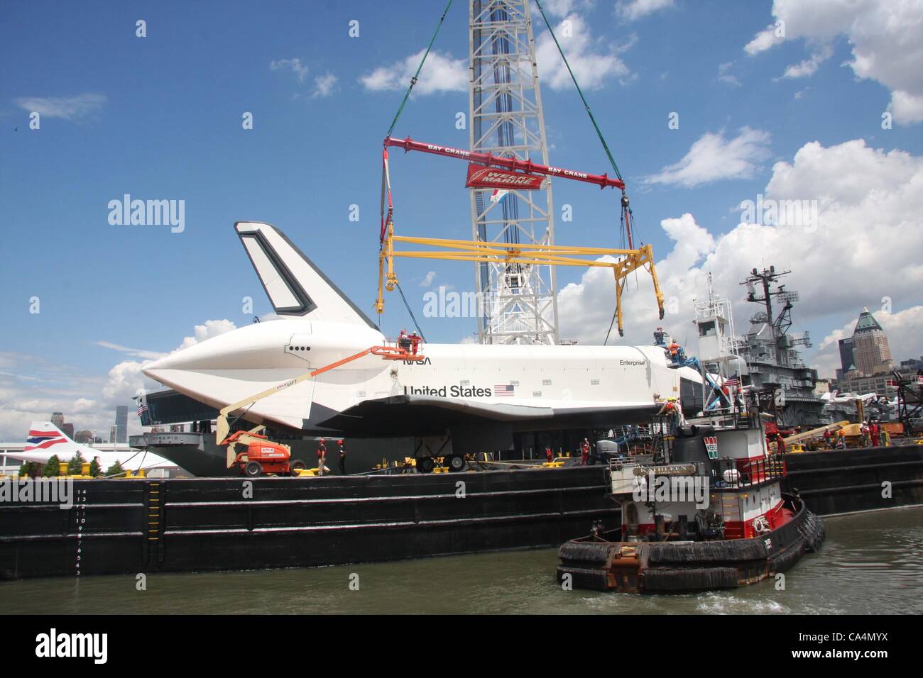 Space Shuttle Enterprise being lifted by a Crane to the Intrepid flight ...