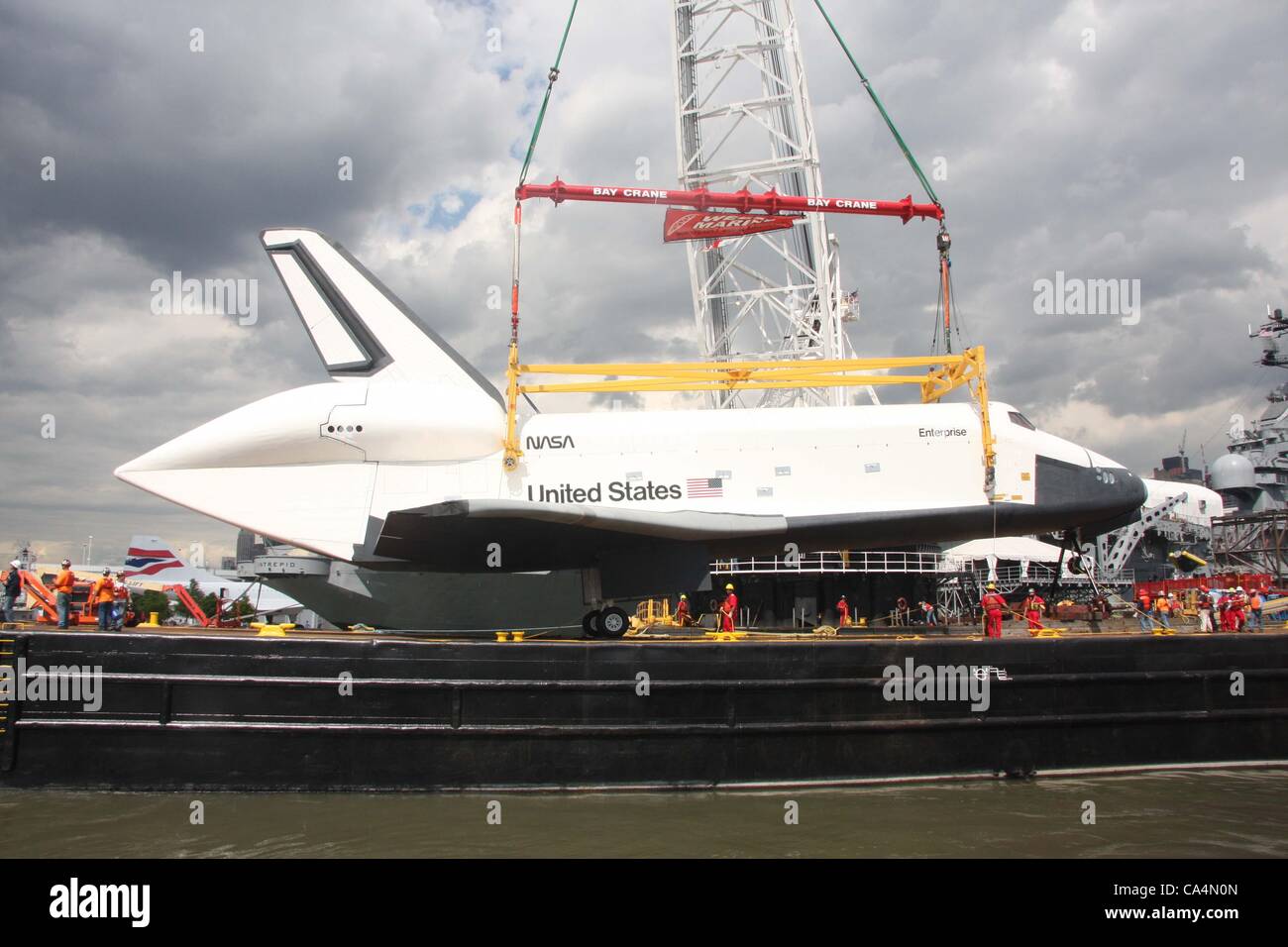 Space Shuttle Enterprise being lifted by a Crane to the Intrepid flight ...