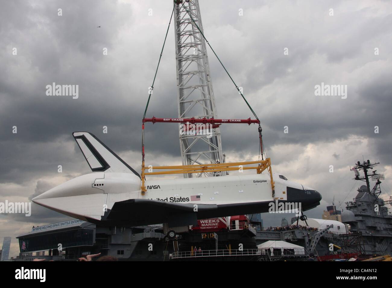 Space Shuttle Enterprise being lifted by a Crane to the Intrepid flight ...