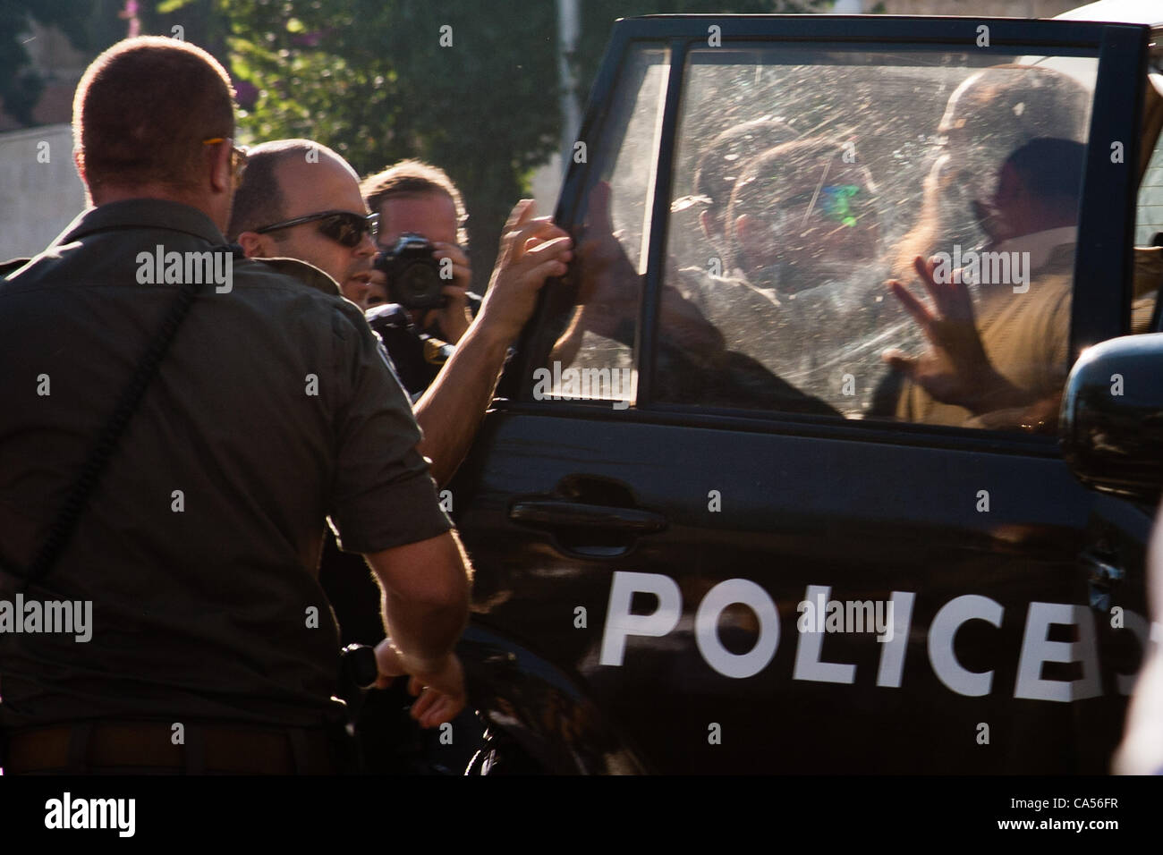 An ultra-Orthodox Haredi man tries to push open police vehicle window ...