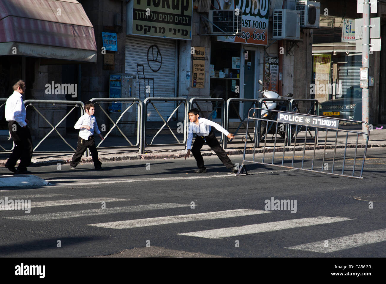 Young ultra-Orthodox Haredi boys run after placing a police barrier on ...