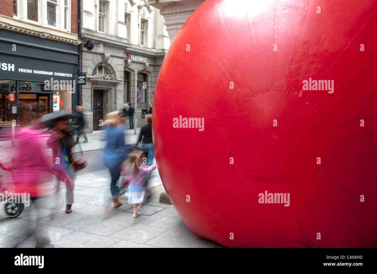 Exeter, UK. 15 June, 2012. Passersby look at Kurt Perschke's giant Red ...