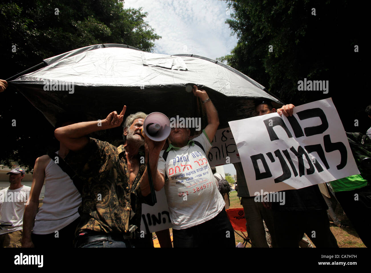 Homeless person holds a placard which reads " Power to the Masses" and ...