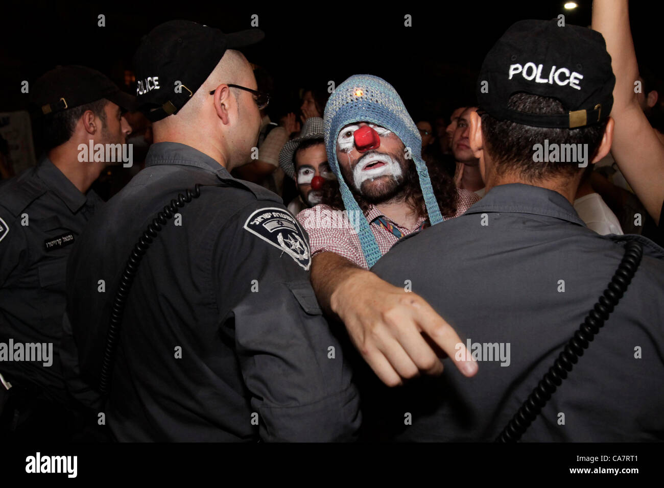 A demonstrator in clown outfit is dragged away by policemen following ...