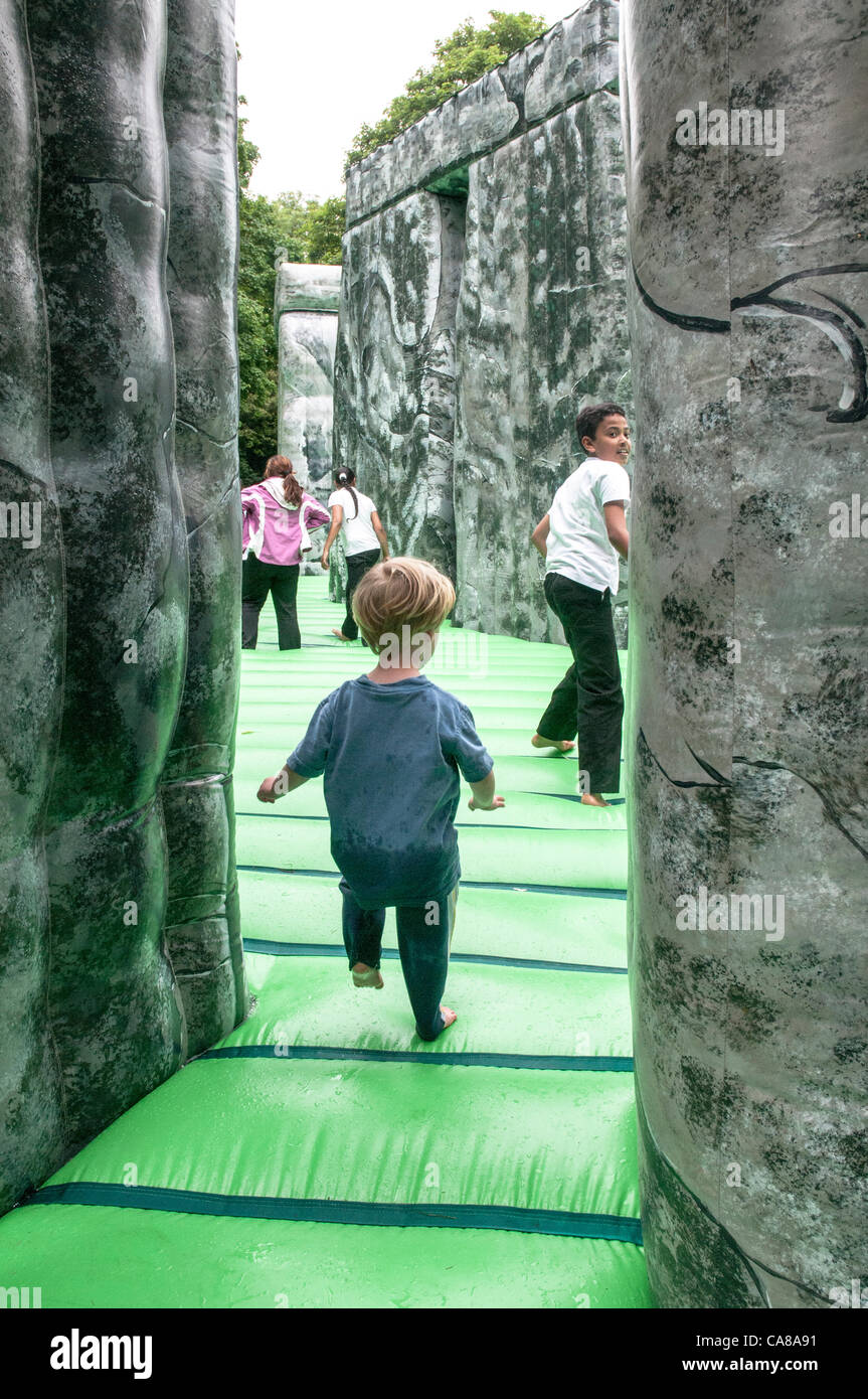 A young child walks between the stones of the life-sized inflatable ...