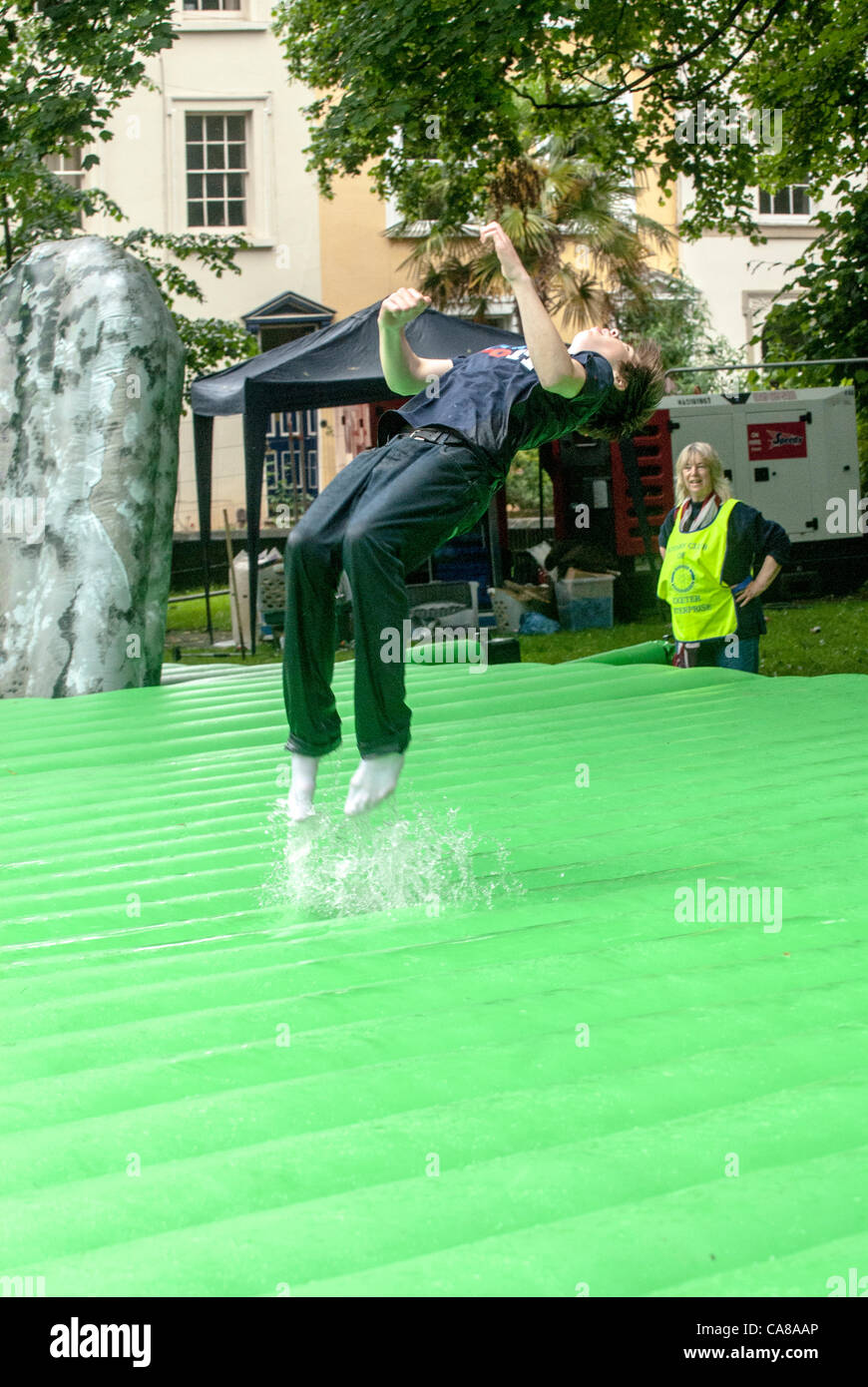 Teenager summersaulting on the life-sized inflatable replica of ...