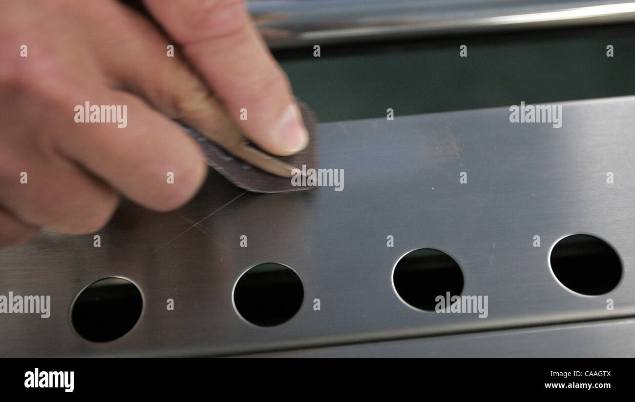 Barry Feinman works to remove a scratch from a stainless steel ...