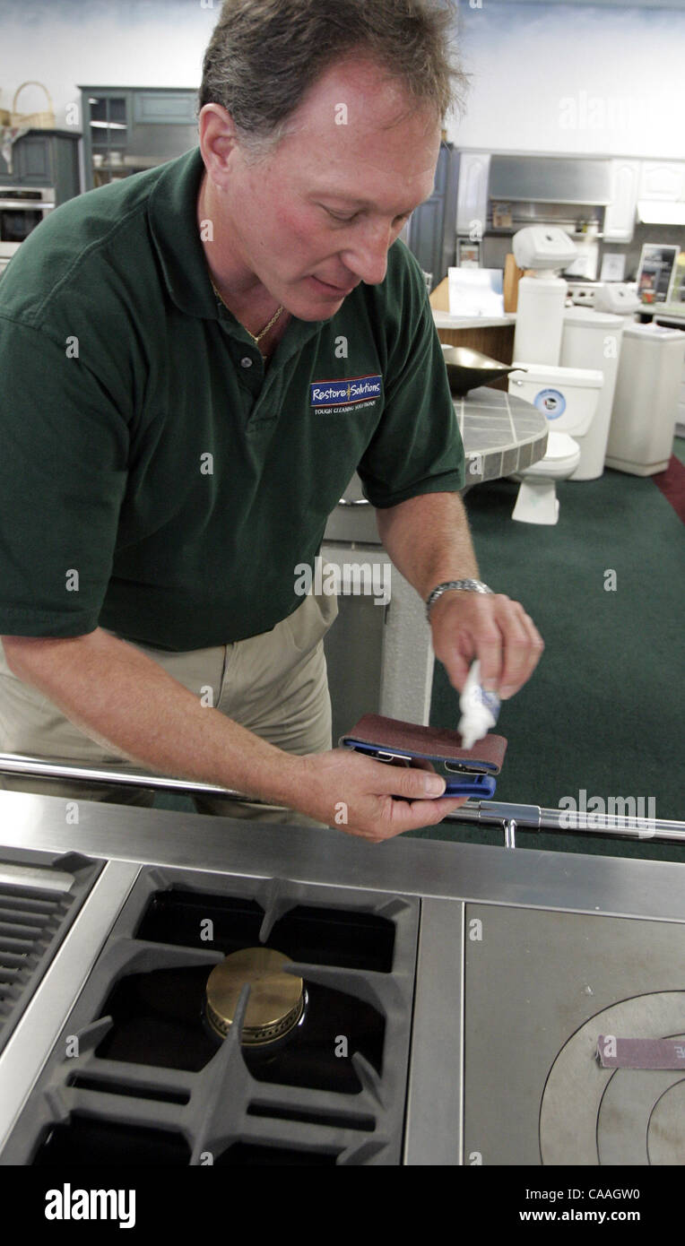 Barry Feinman works to remove a scratch from a stainless steel ...