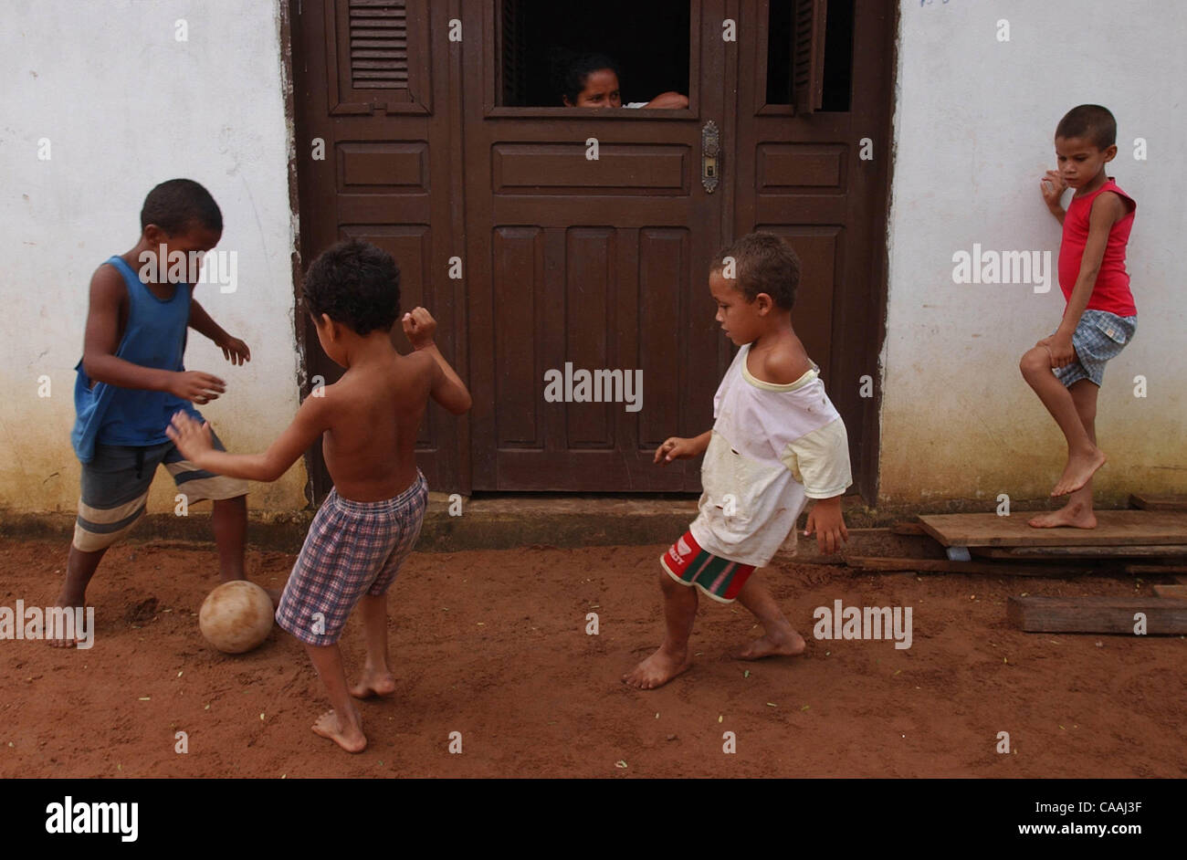 Maria da Rocha Marinllo watches her children play outside her home in ...