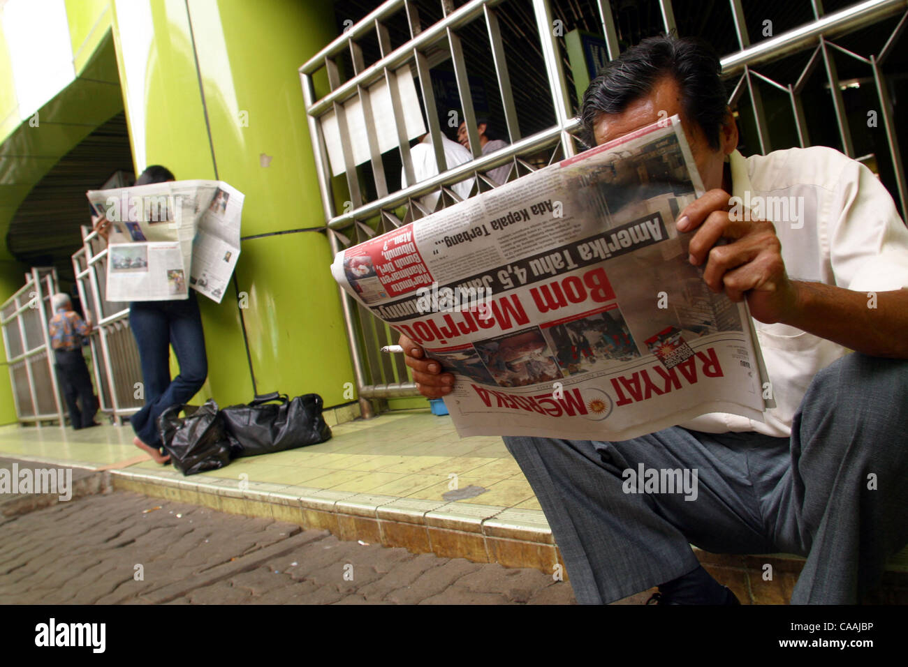 JAKARTA, INDONESIA - AUGUST 6, 2003 A Jakarta man reads a newspaper ...