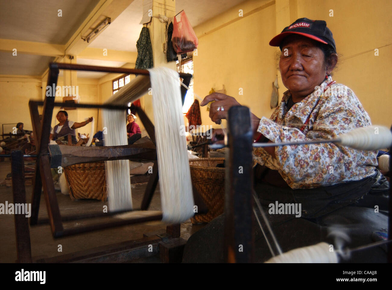 KATHMANDU, NEPAL- AUGUST 29, 2003- A Tibetan knits wool's yarn to make ...