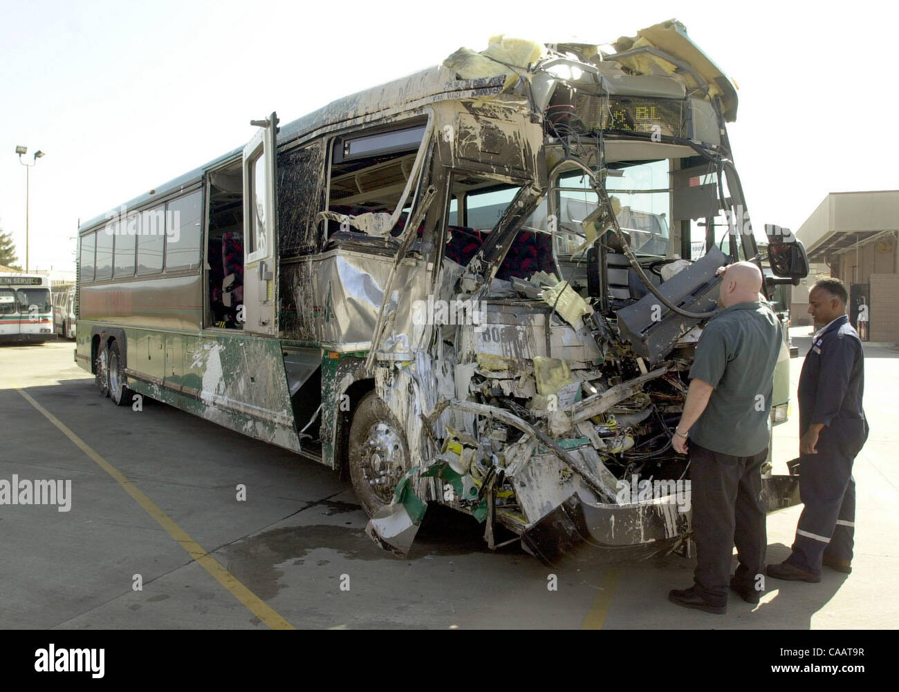 Workers look over an AC transit bus at the Oakland maintenance facility ...