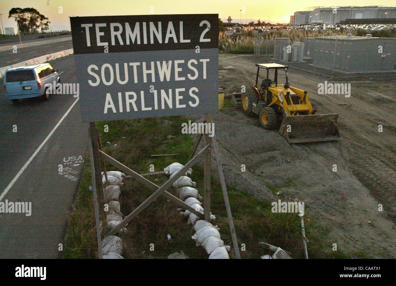 A temporary sign along Airport Drive is posted near a construction site ...