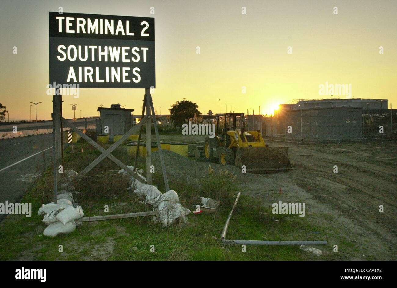 A temporary sign along Airport Drive is posted near a construction site ...