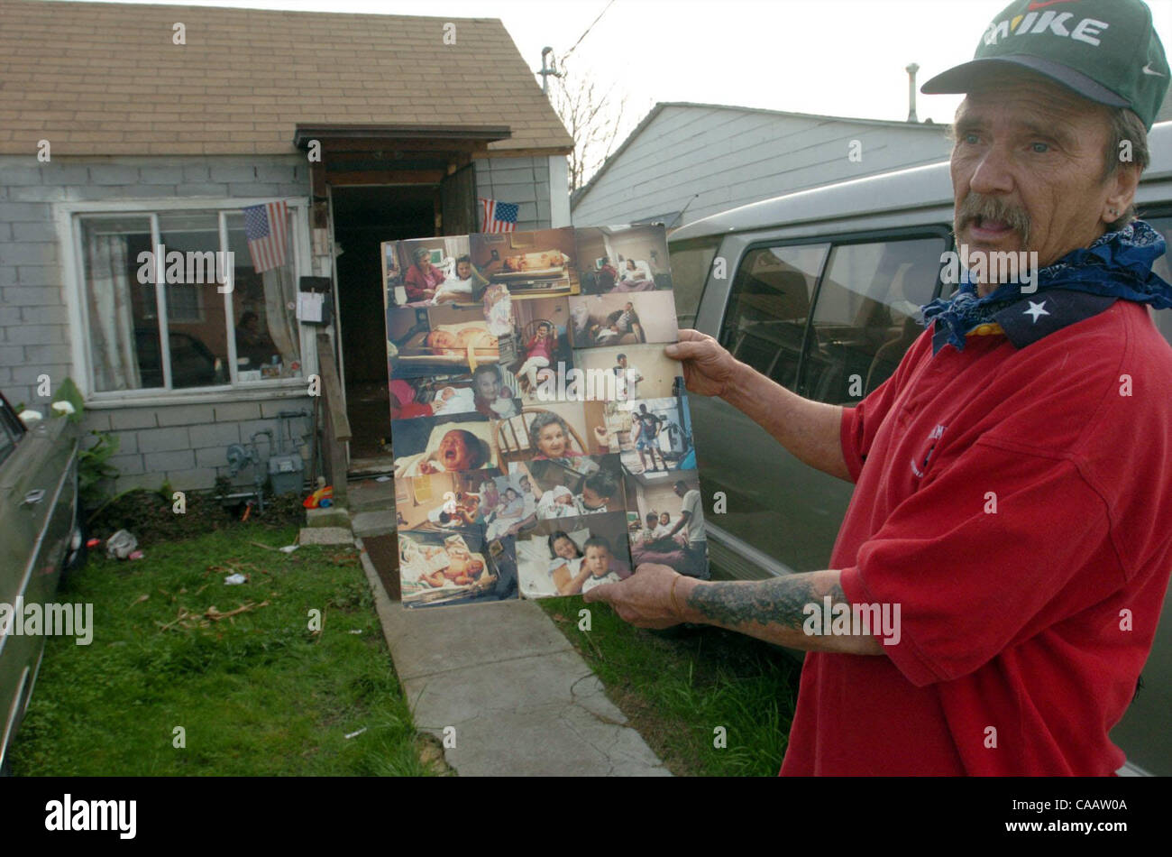 James Don Lisby, son of Ollie Lisby, shows a board of family photos ...