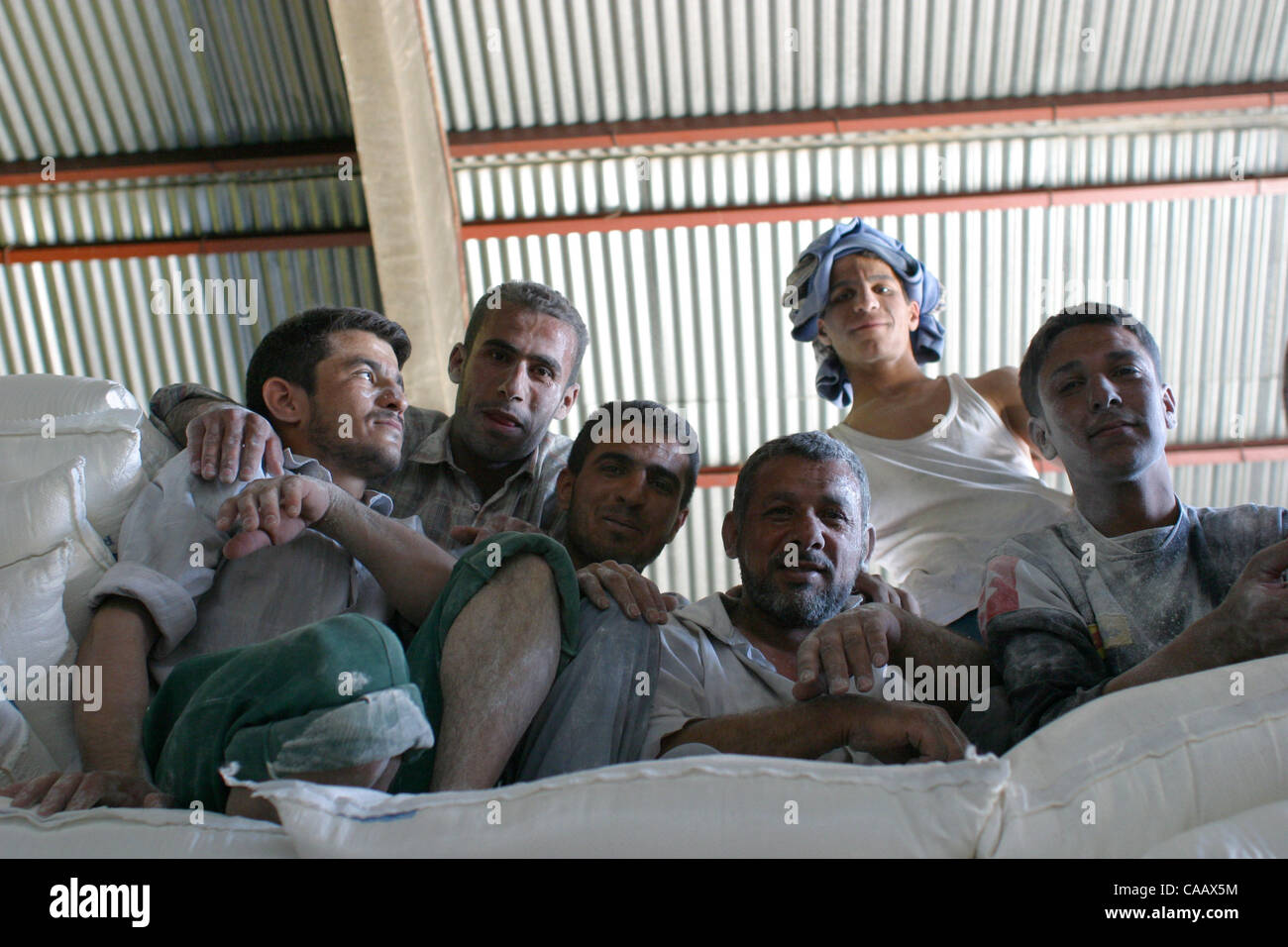 Iraqis work at the World Food Program distribution center in Baghdad ...