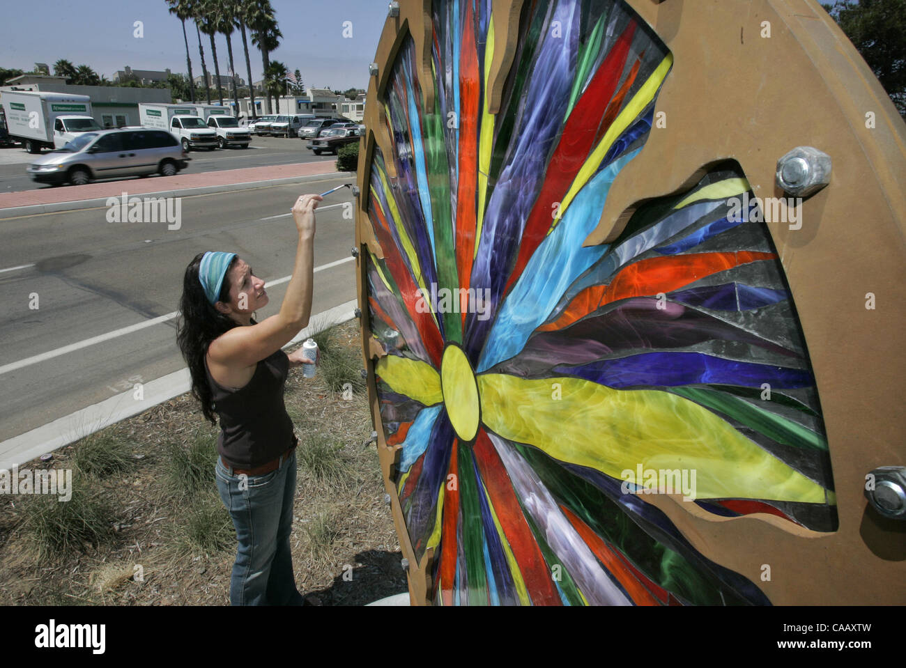 Artist AMBER IRWIN paints patina on the steel bolts that are finishing ...