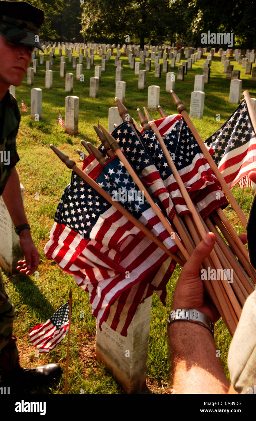 U.S. Marines place flags in front of each of the 290,000 grave markers ...