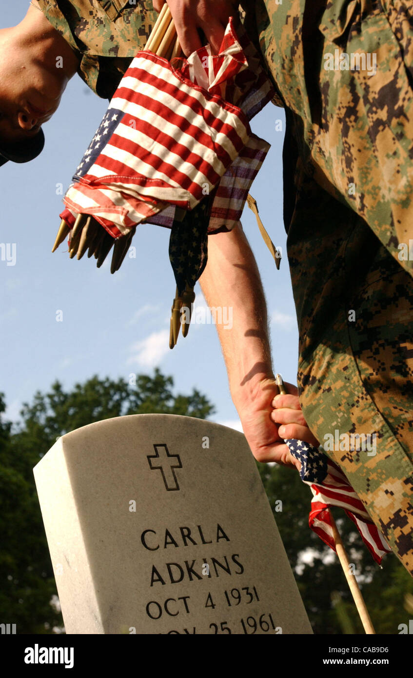 U.S. Marines place flags in front of each of the 290,000 grave markers ...