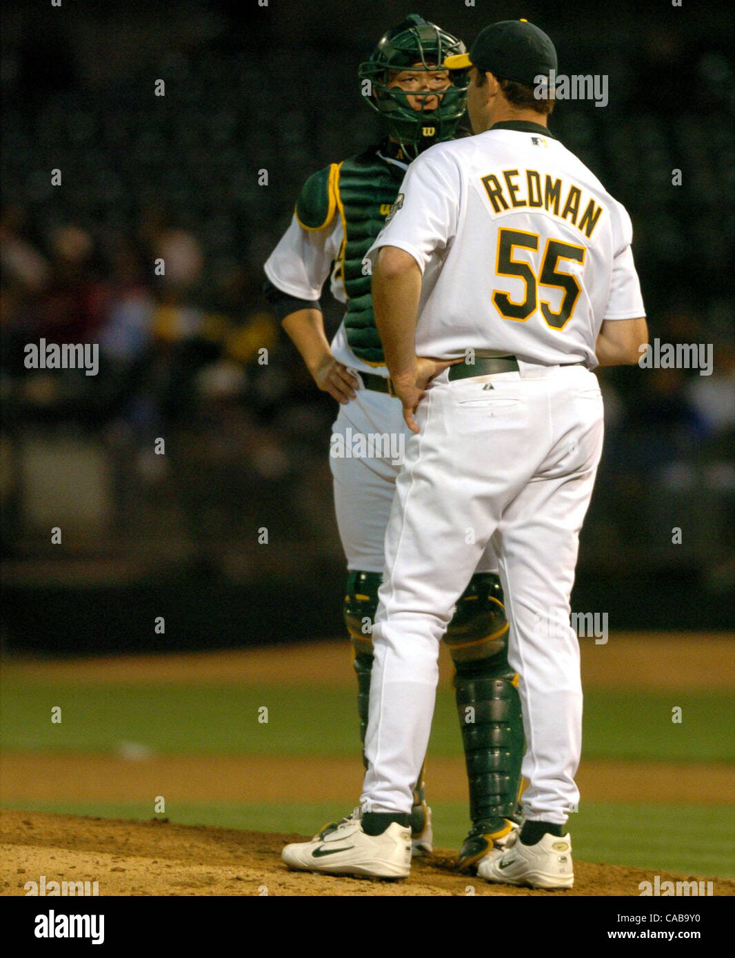 Catcher Damian Miller and pitcher Mark Redman of the Athletics talk ...