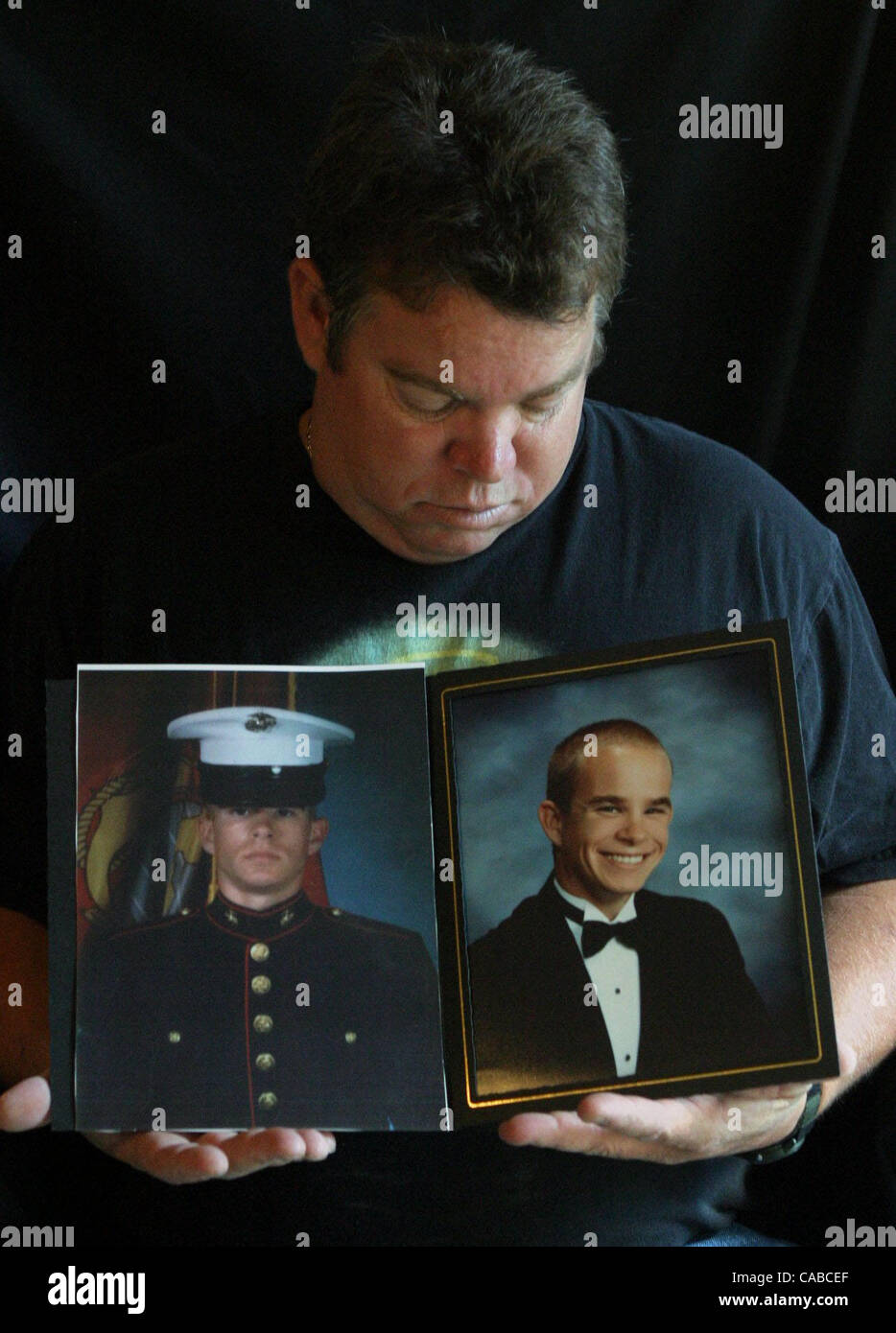 Mark Crowley (cq), father of Kyle Crowley (cq), poses with photos of ...