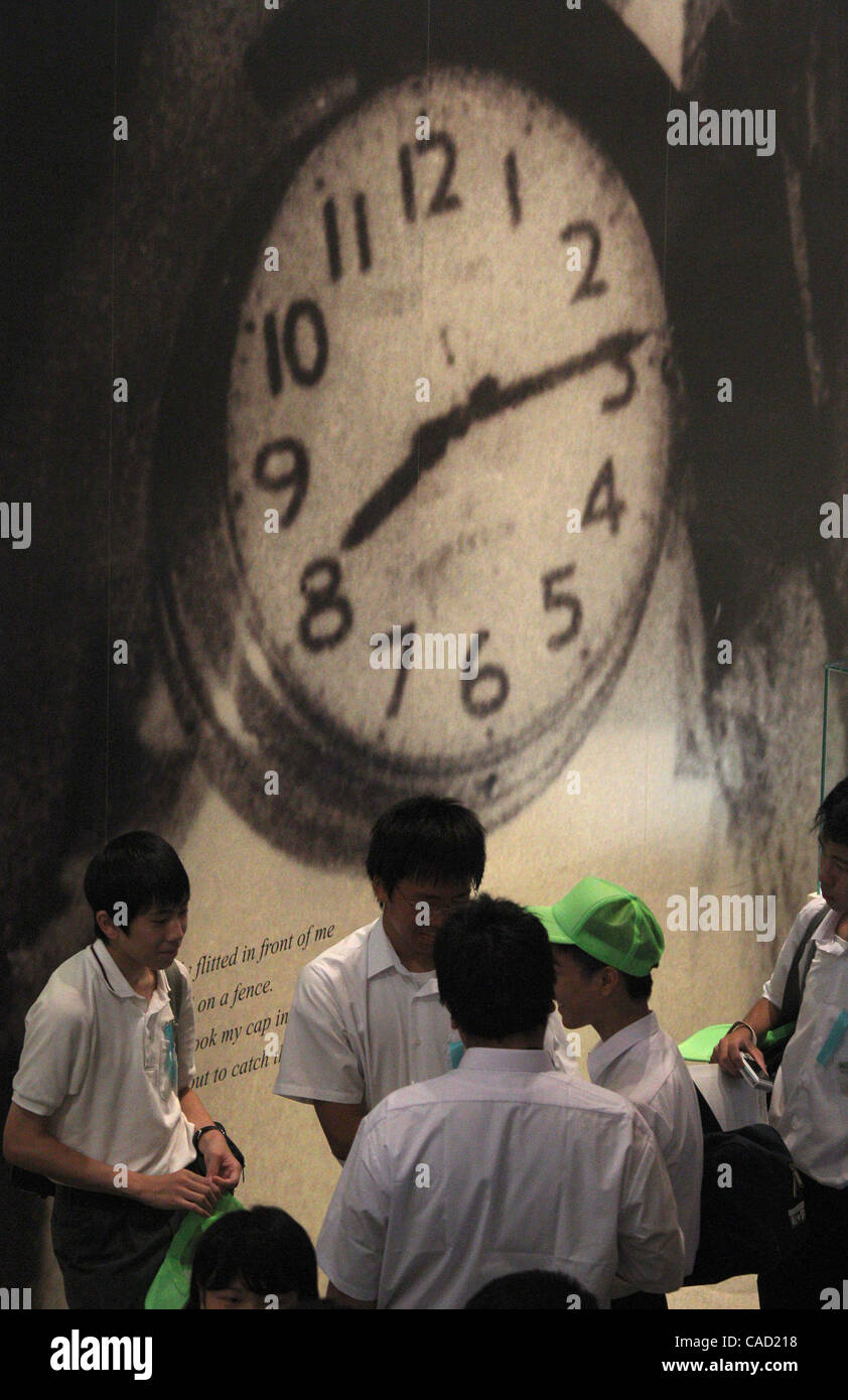 Aug 06, 2010 - Hiroshima, Japan - Visitors walk past a picture of a ...