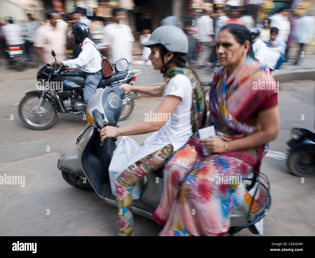 Travelers crowd onto motorcycles on the road in Bangalore, Karnataka ...