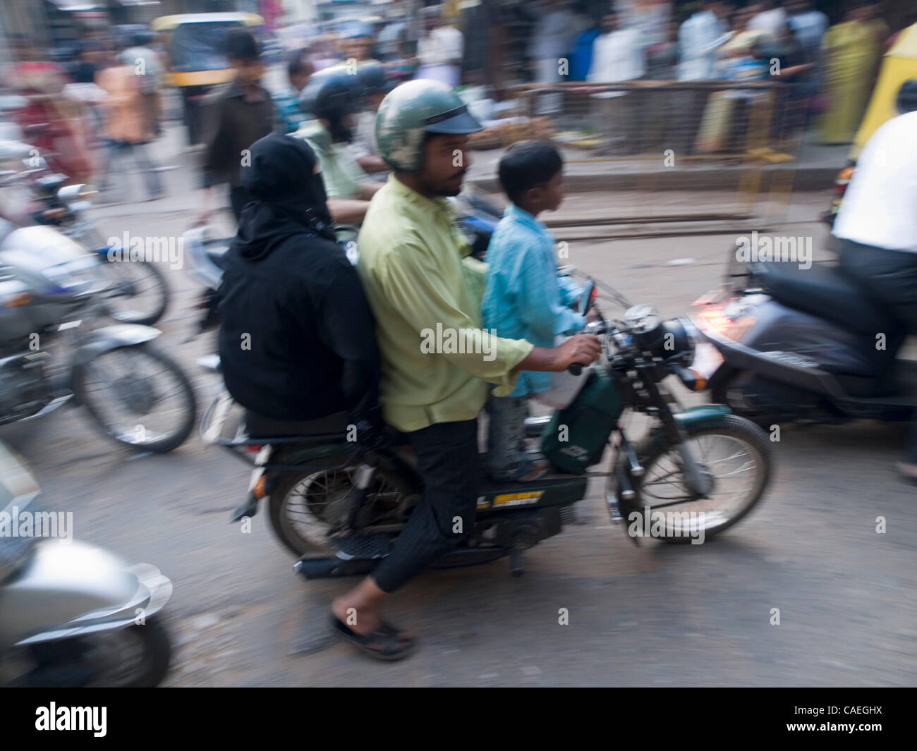 Travelers crowd onto motorcycles on the road in Bangalore, Karnataka ...