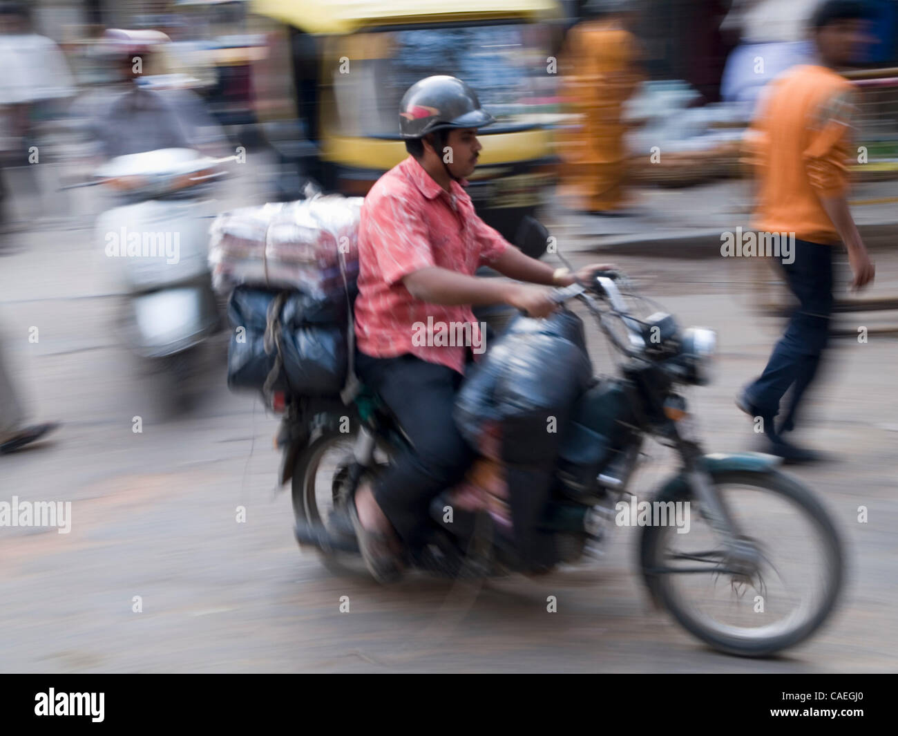 Travelers crowd onto motorcycles on the road in Bangalore, Karnataka ...