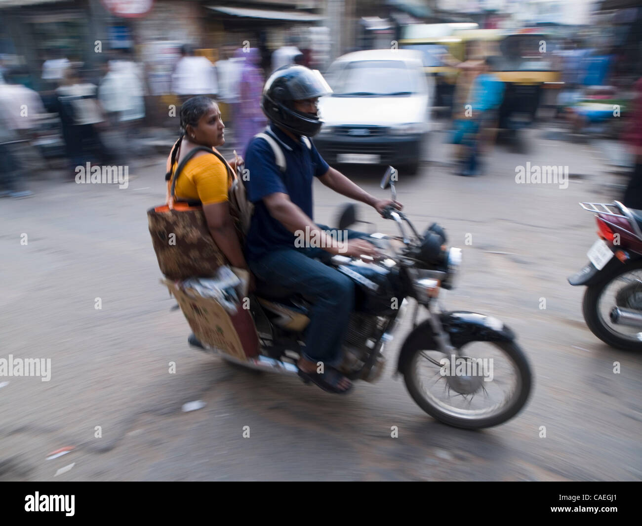 Travelers crowd onto motorcycles on the road in Bangalore, Karnataka ...