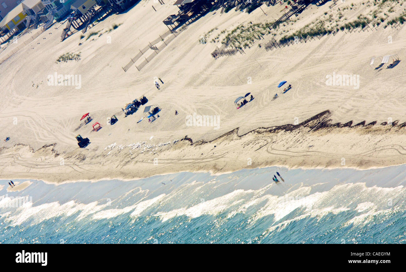 Clean up crews pick up oil from the beach in Gulf Shores, Alabama USA ...