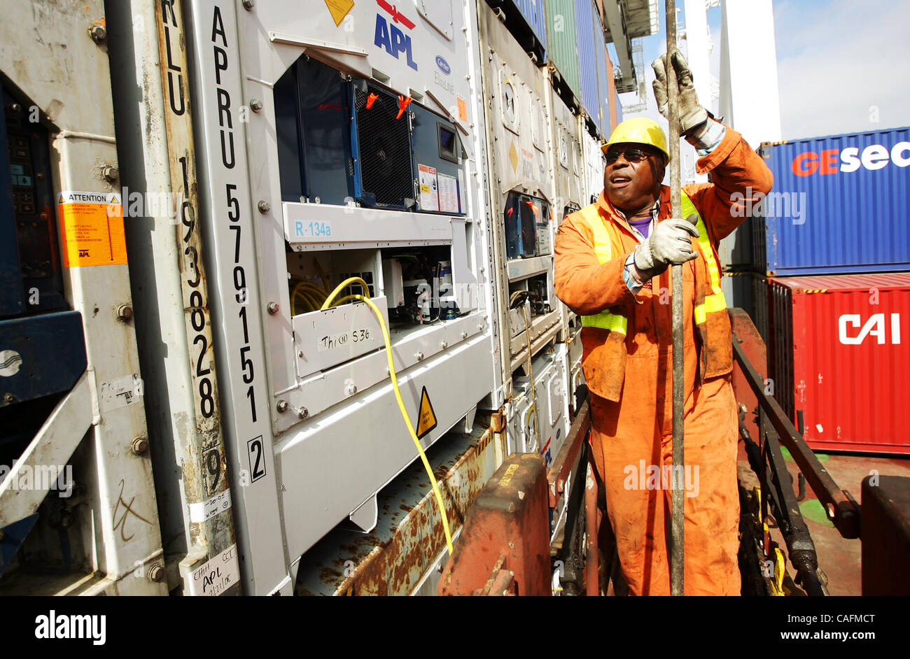 Longshoreman Ted Frazier uses long rods with turnbuckles to secure ...