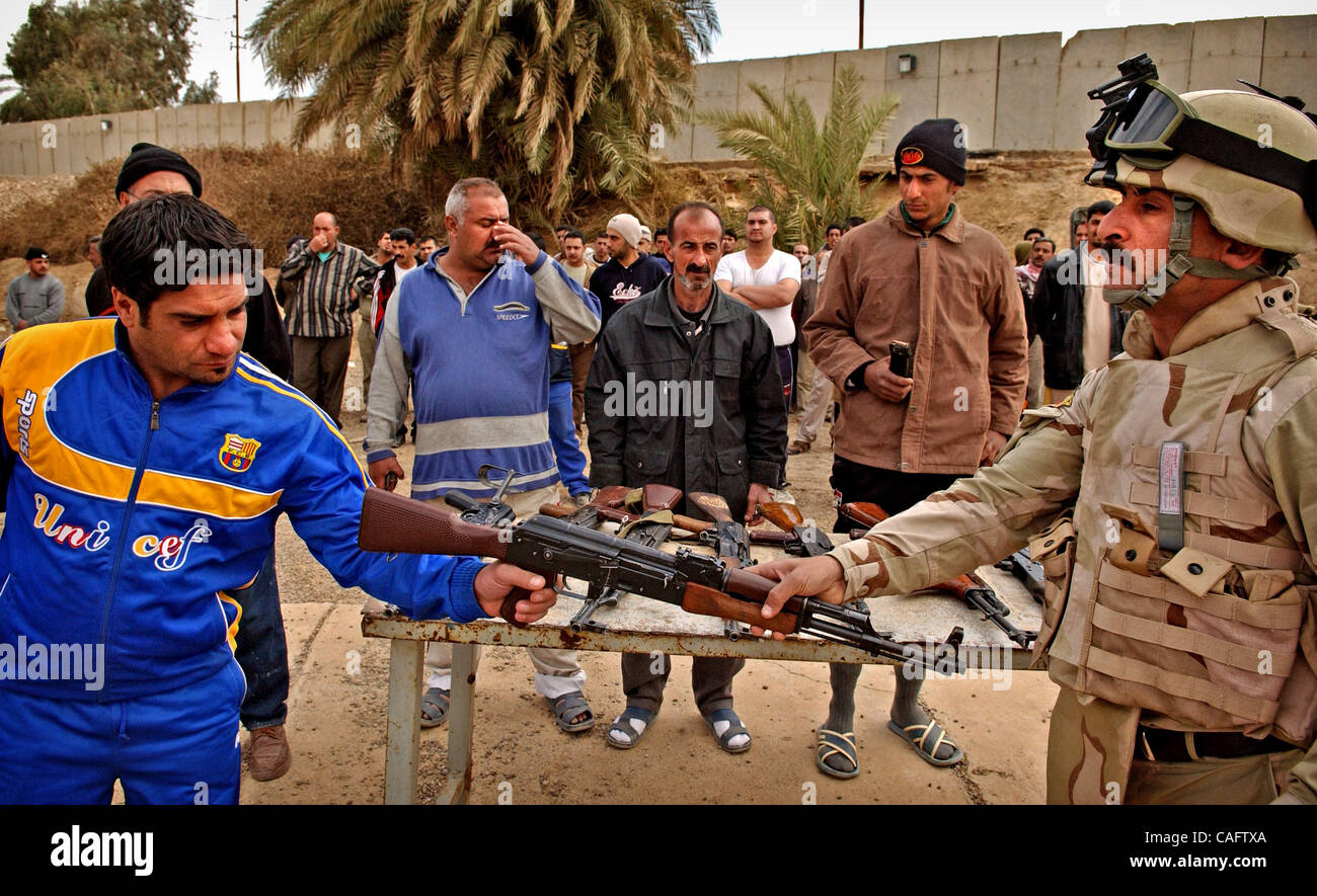 Feb 20, 2008 - Baghdad, Iraq - An instructor hands an AK-47 to a Sons ...
