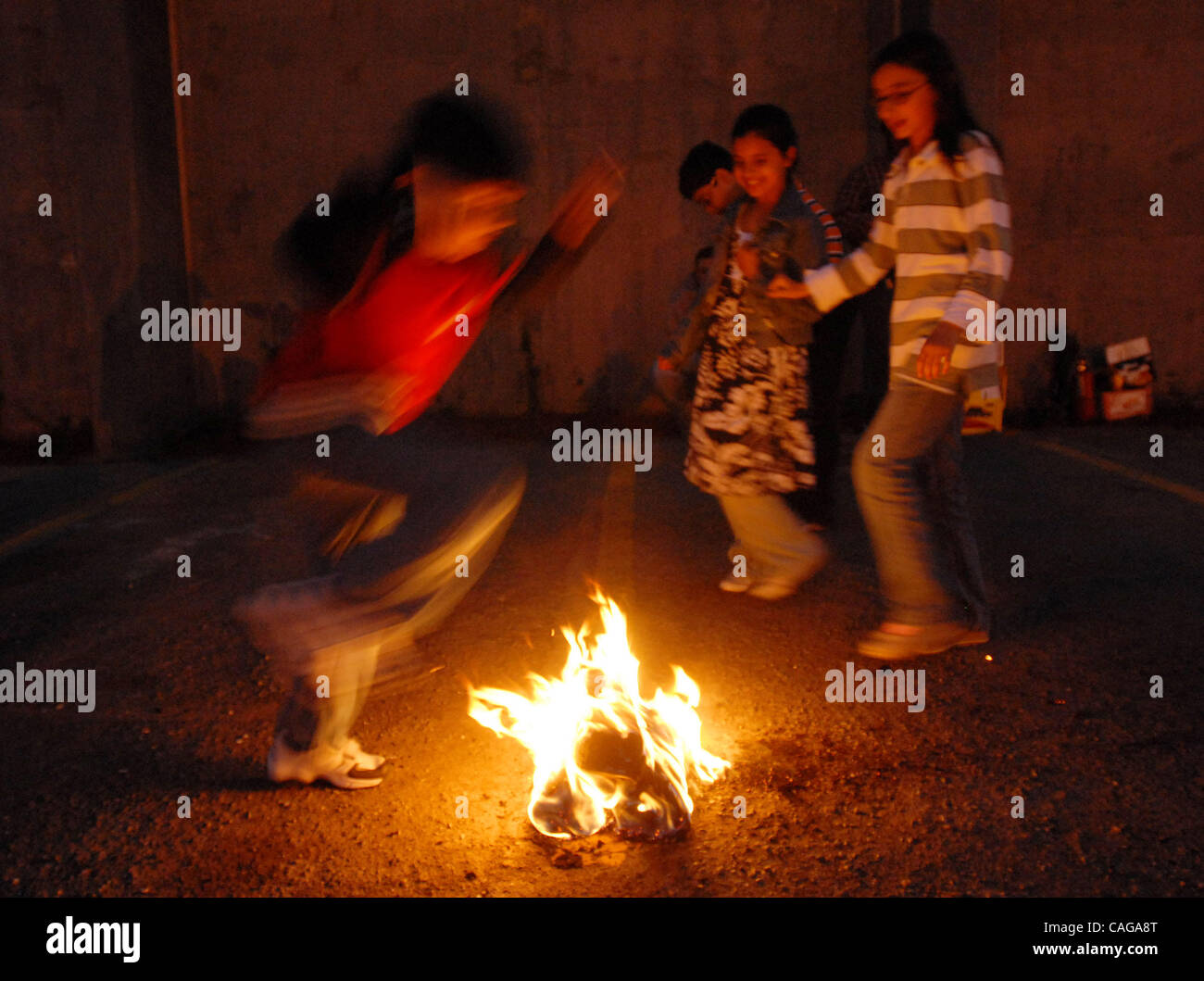 Kids take turns jumping over fire during a Persian New Year celebration ...