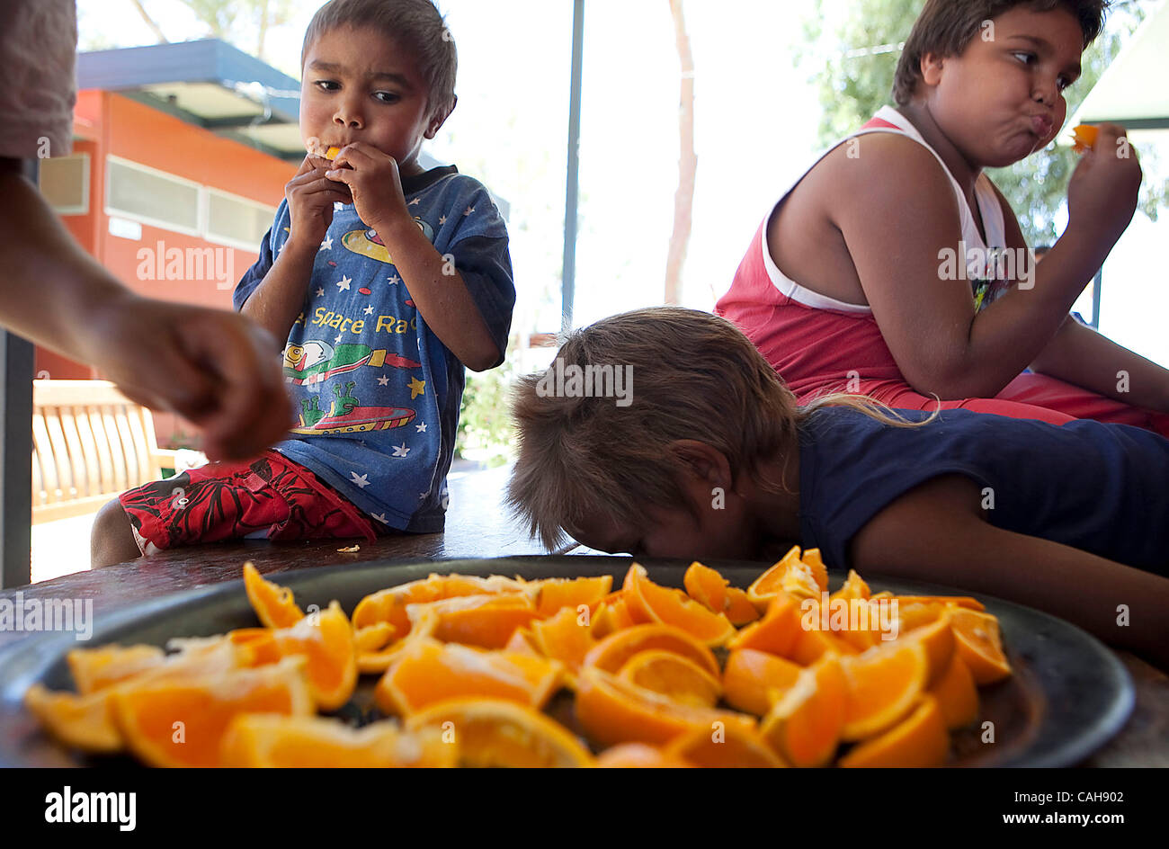 Children at the Mt. Margaret Remote Community School eat sliced oranges ...