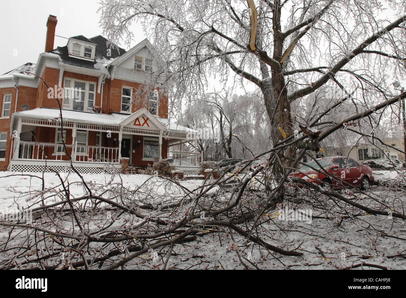 Ice covered tree branches and limbs litter the ground in front of a ...