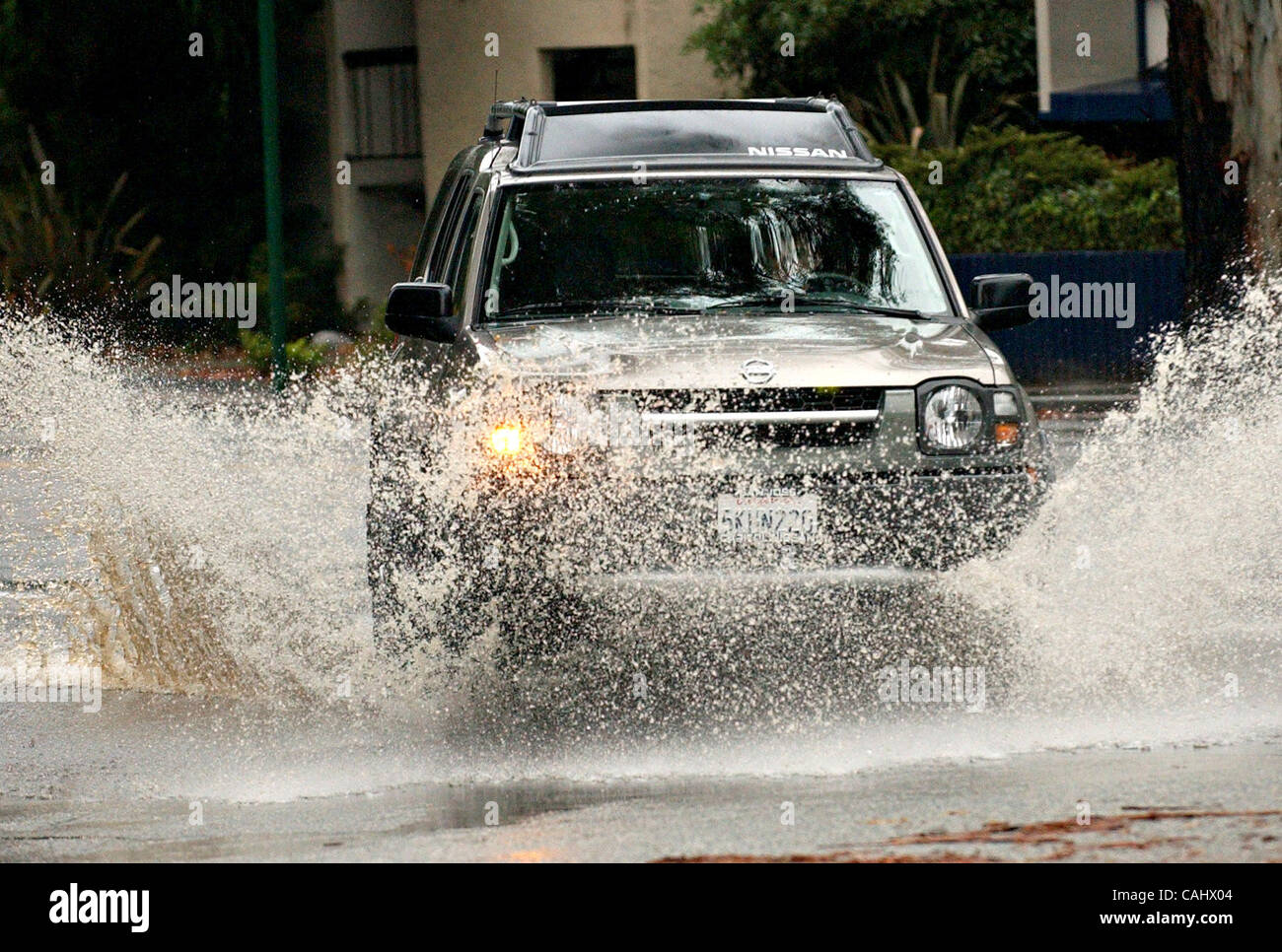 A vehicle drives through a flooded section of El Camino Real in ...
